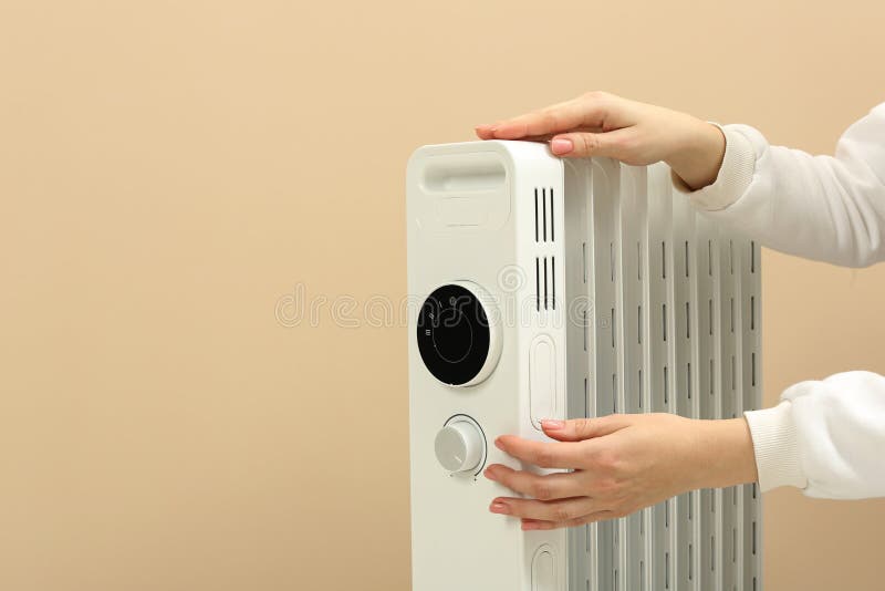 Young Woman Adjusting Temperature on Modern Electric Heater Against ...