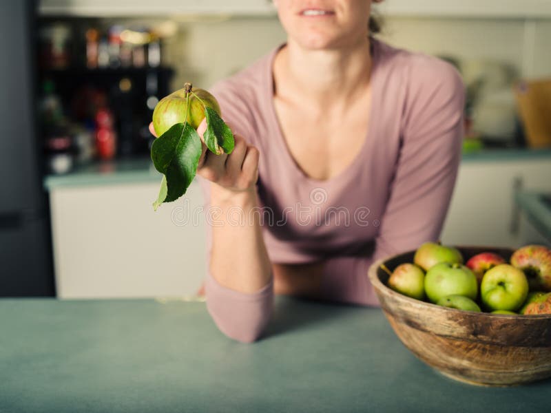 Young Woman with Apple in Kitchen Stock Photo - Image of hand, interior ...