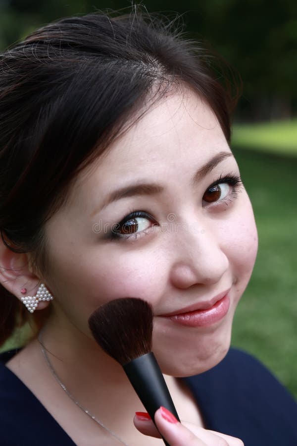 Young Woman Applying Blusher Stock Photo - Image of attractive, casual ...