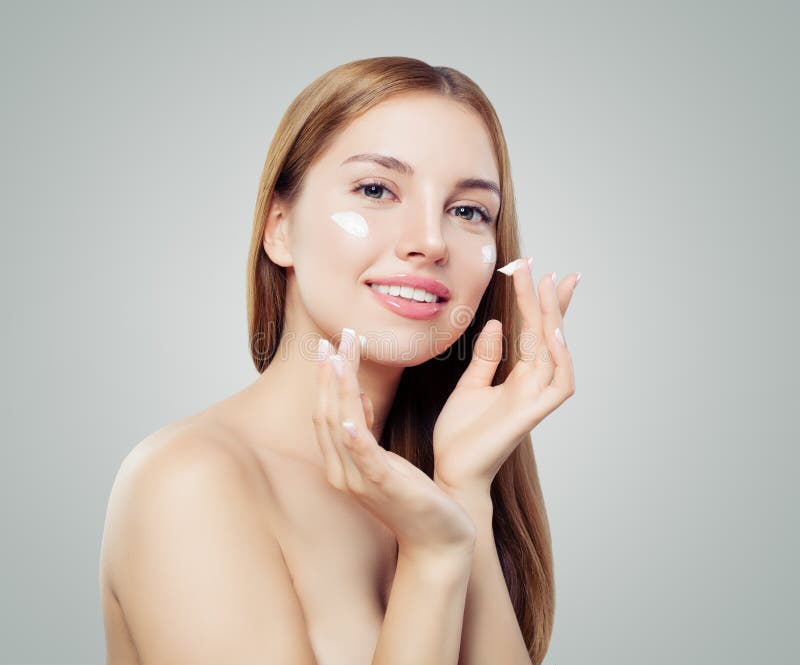 Young Woman Applying Cream On Her Clear Skin Beautiful Female Face