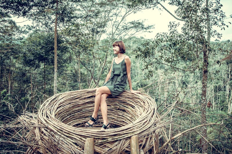 Young Woman In Artificial Nest In Rainforest Of Tropical Bali Island