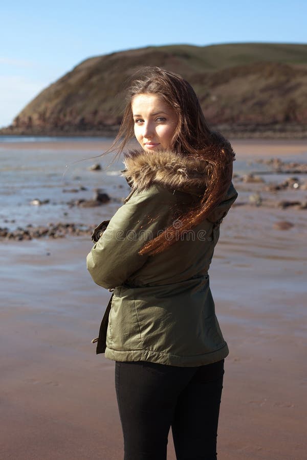 Young Woman at the Beach All Wrapped Up Against the Wind Stock Photo ...