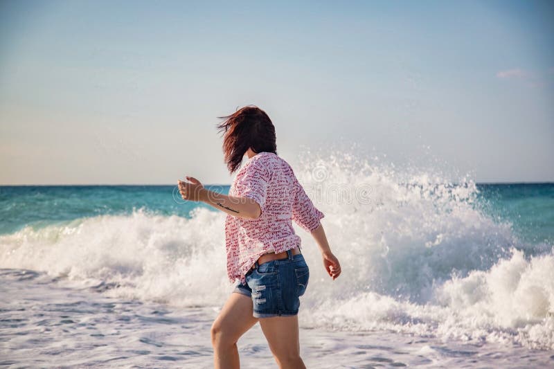 Young Woman at the Beach Running Away from the Waves Stock Photo ...