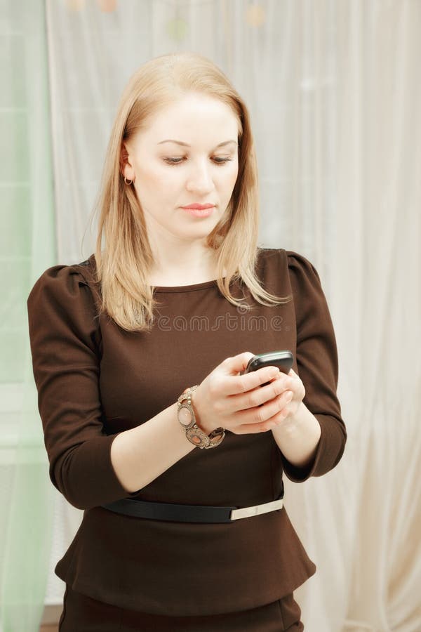 Woman in brown texting stock image. Image of blonde, cellphone - 29786123