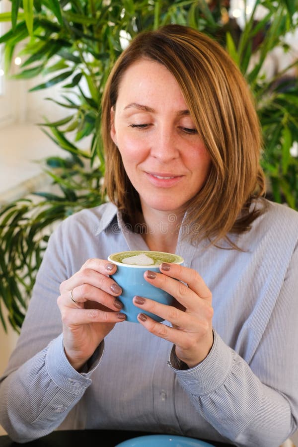 Young Woman in Cafe Sipping Matcha Tea from a Cup Stock Image - Image ...