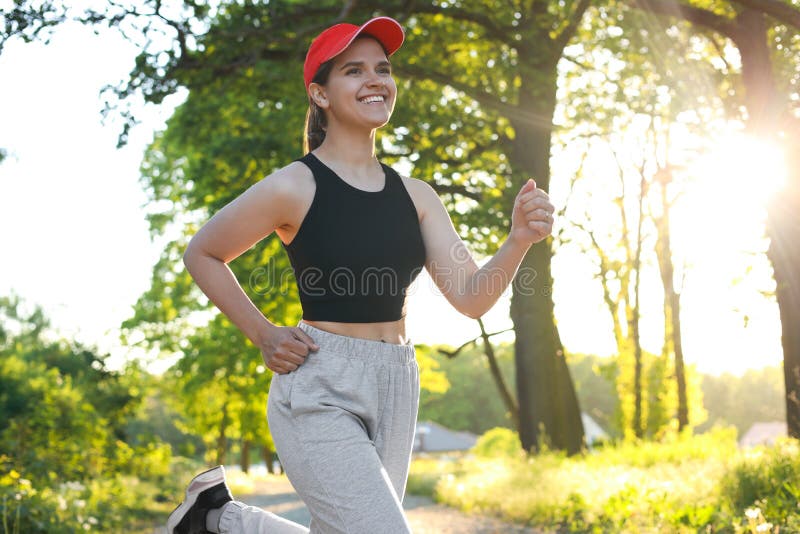 Young Woman with Cap Running Outdoors in Morning Stock Image - Image of ...