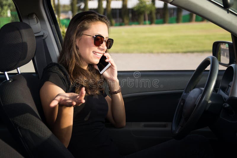 A Smiling Young Woman in the Car Talks on the Smart Phone Stock Photo ...