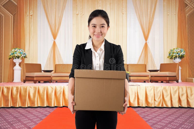 Young Woman Carrying a Box Wtih Smile in a Conference Hall Stock Photo ...
