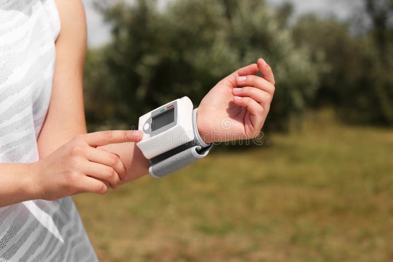 Young Woman Checking Pulse with Medical Device Training in Park ...
