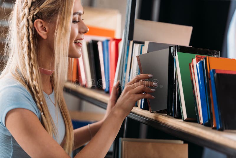 Young Woman Choosing Book on Bookshelf in Library Stock Image - Image ...