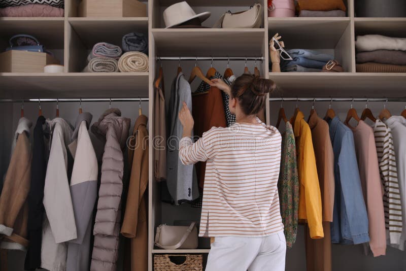 Young Woman Choosing Clothes in Wardrobe Closet, Back View Stock Photo ...