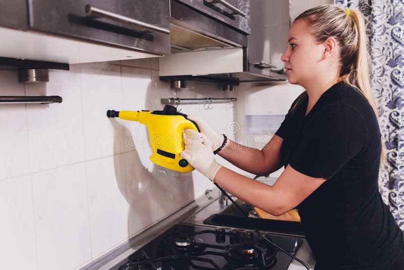 Young Woman Cleaning Kitchen with Steam Cleaner. Stock Photo - Image of ...