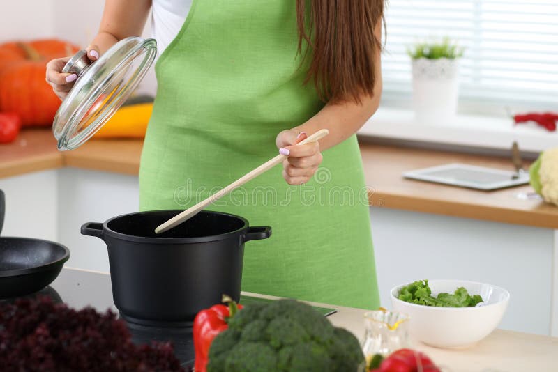 Young Woman is Cooking by the Stove in the Kitchen, Close Up. Stock ...