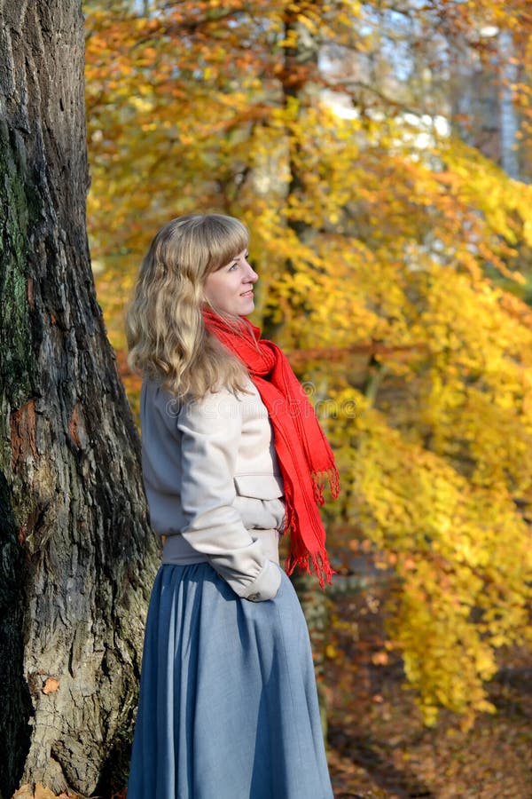 The Young Woman Costs Sideways Against the Background of an Autumn Tree ...