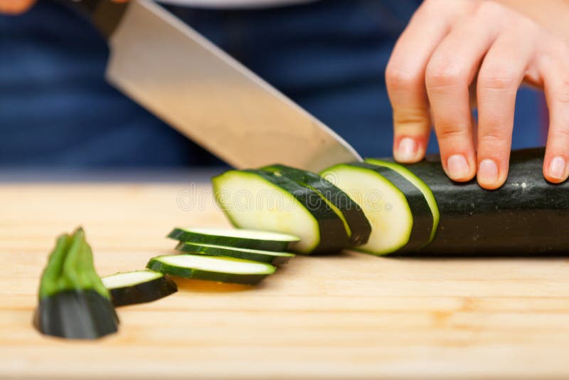 Woman cutting zucchini stock photo. Image of chopping - 131823070