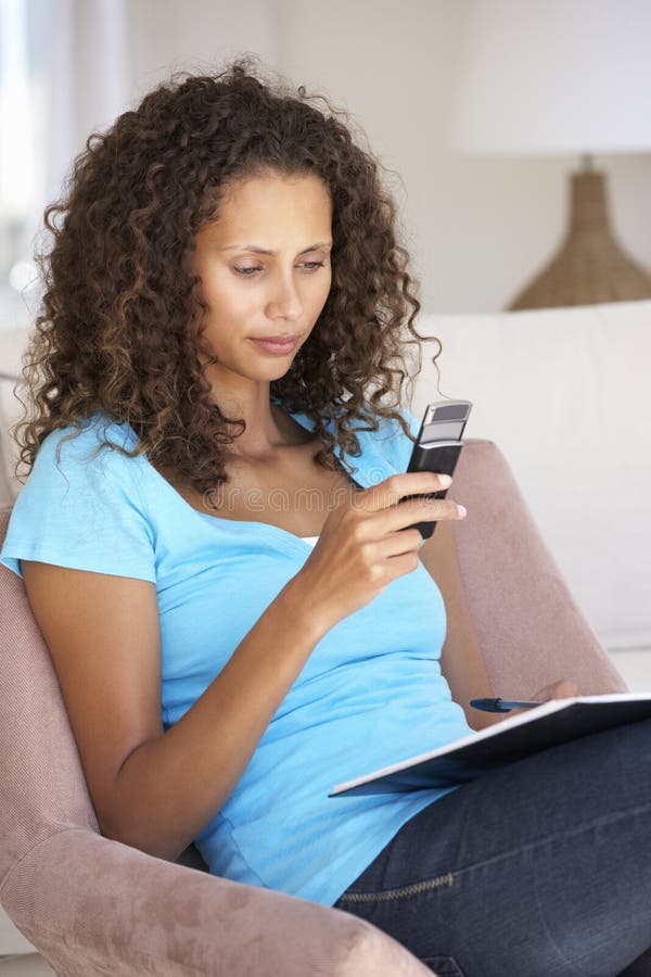 Young Woman Doing Paperwork and Using Mobile Phone at Home Stock Image ...