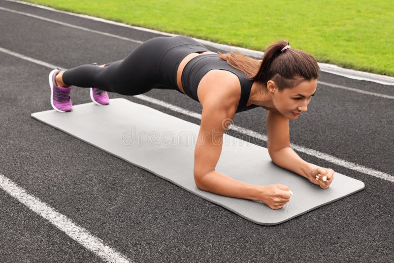 Young Woman Doing Plank Exercise at Stadium Stock Image - Image of ...