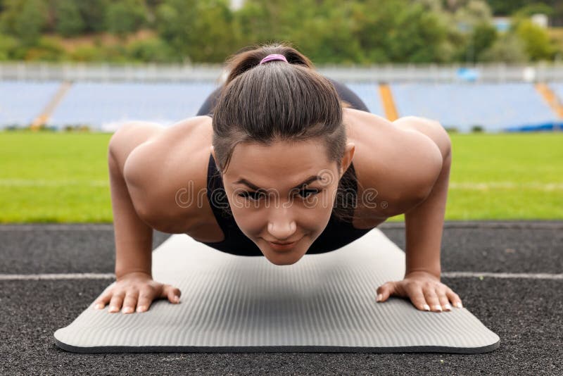 Young Woman Doing Plank Exercise at Stadium Stock Image - Image of ...