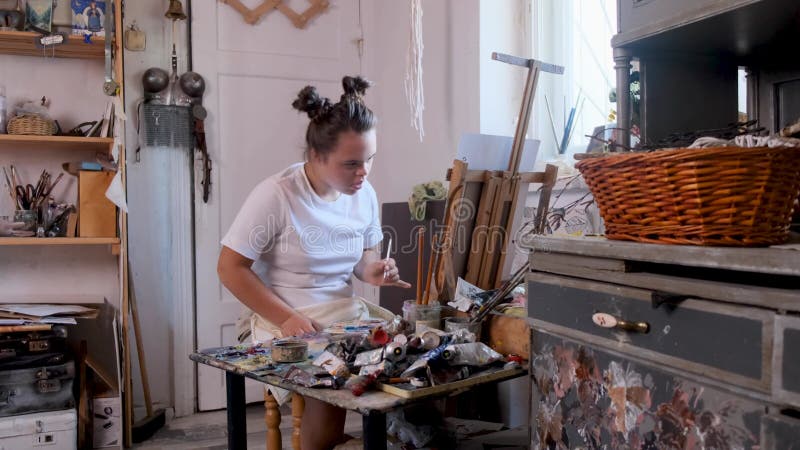 A Young Woman with Down Syndrome is Deeply Absorbed in Her Art ...