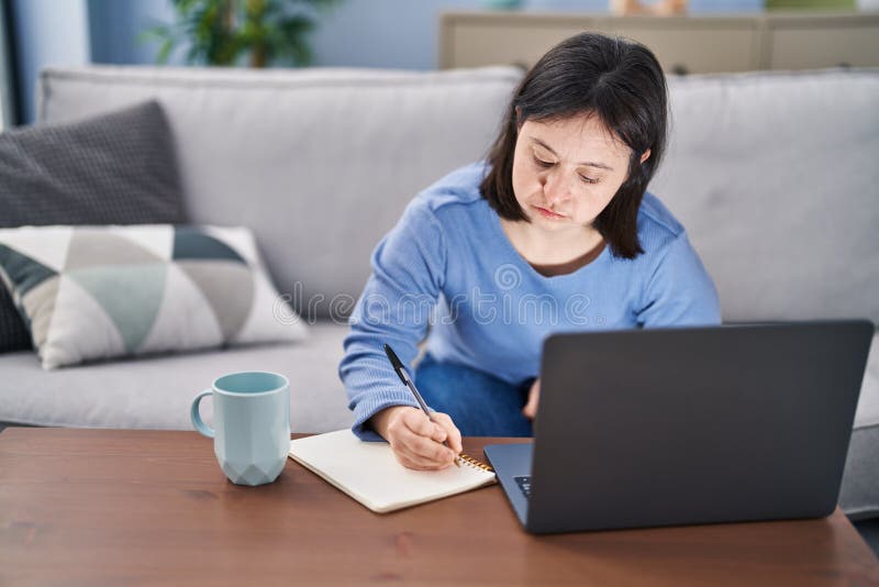 Young Woman with Down Syndrome Sitting on Sofa Write on Notebook ...
