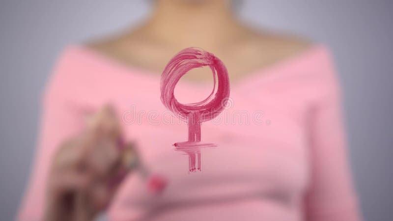 A Young Woman Draws A Female Symbol On The Glass Sex Symbol In Pink