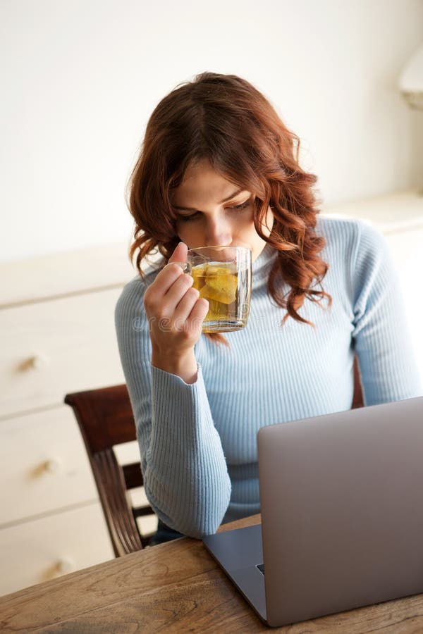 Young Woman Drinking Tea while Working on Laptop Computer Stock Image ...