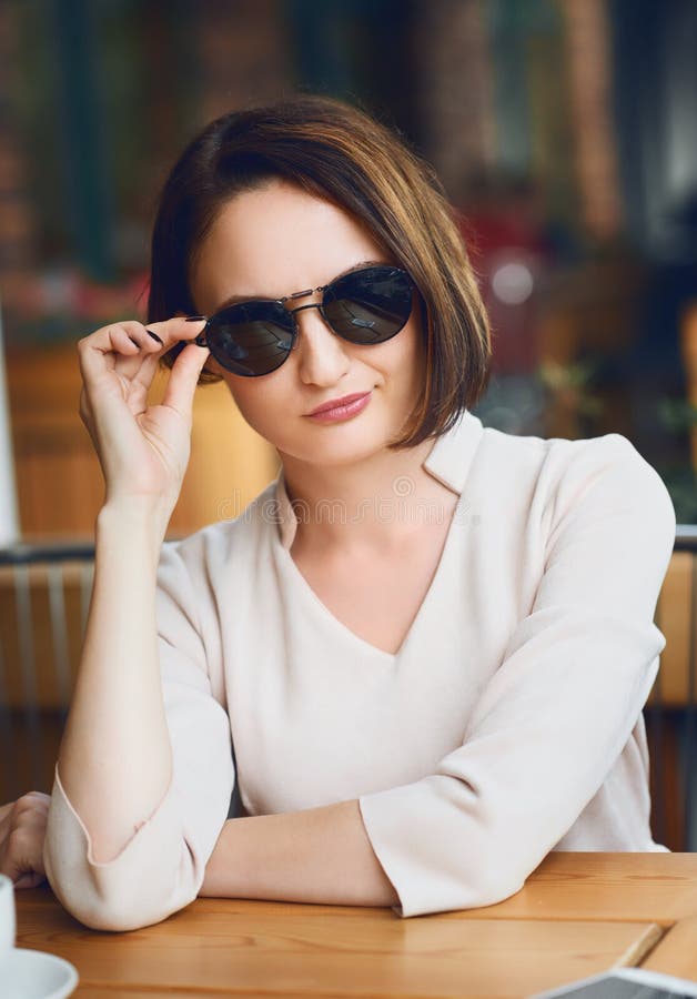 Young Woman Drinks Coffee In Cafeteria And Posing With Sunglasses Stock Image Image Of Modern