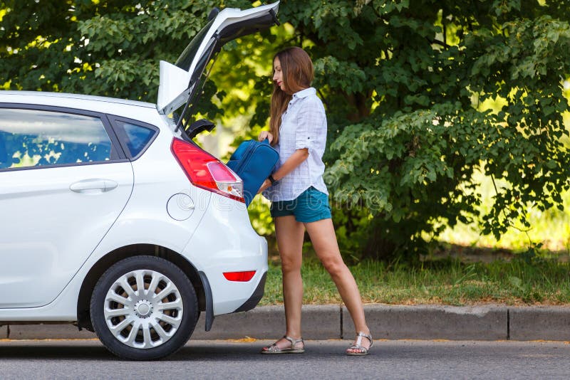 Young Woman Driver Loading Suitcase in the Car Trunk Stock Photo ...