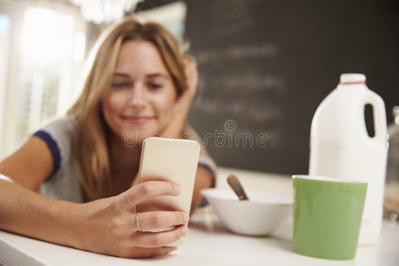 Young Woman Eating Breakfast Whilst Using Mobile Phone Stock Image ...