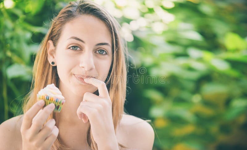 Young Woman Eating Cupcake. Stock Image - Image of life, licking: 95712733