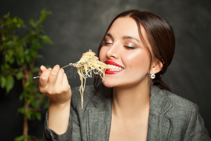 Young Woman Eating Italian Pasta In Restaurant And Smiling Stock Image