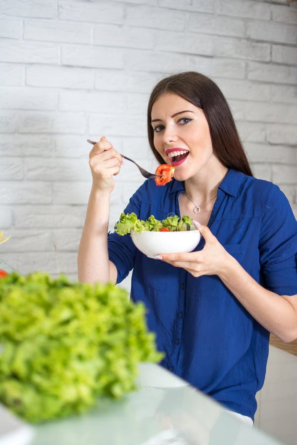Young Woman Eating Salad and Holding a Mixed Salad. Stock Photo - Image ...