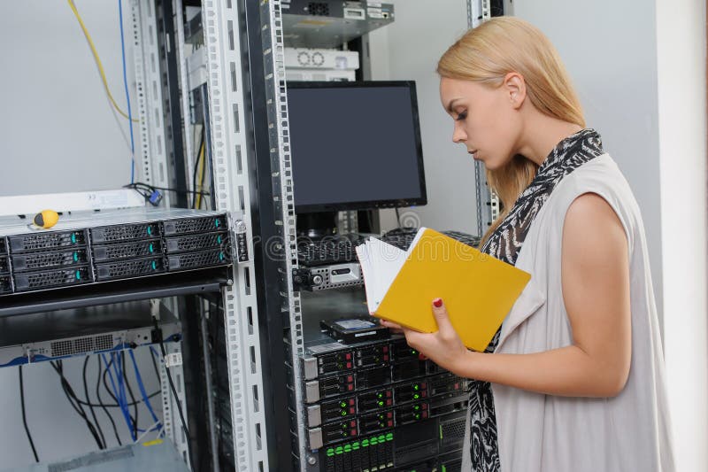Young Woman Engineer it between the Server Racks in the Data Center ...