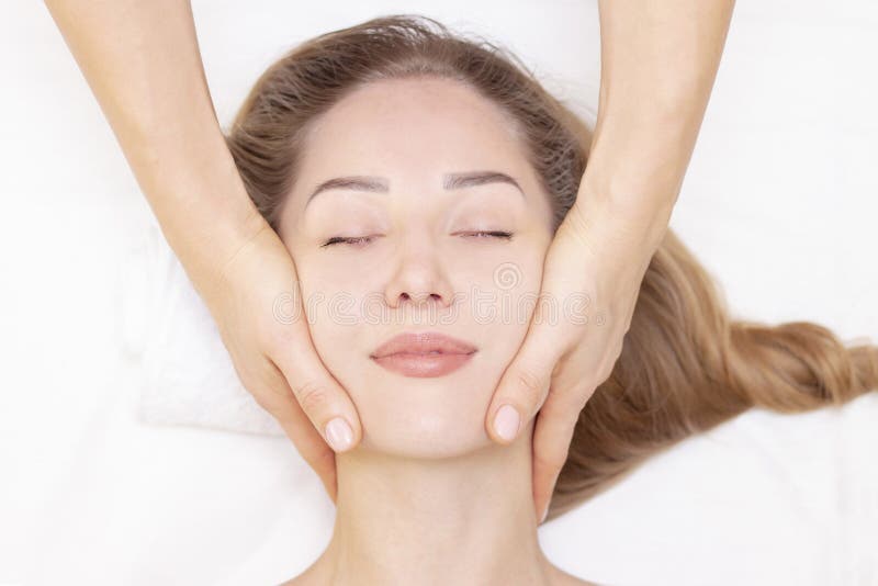 Young Woman Enjoying Massage In Spa Salon Face Massage Closeup Of