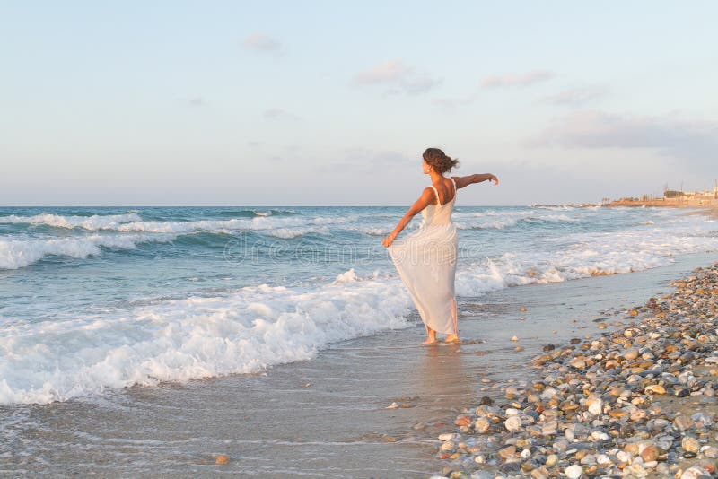 Young Woman Enjoys Walking On A Hazy Beach At Dusk Stock Image Image