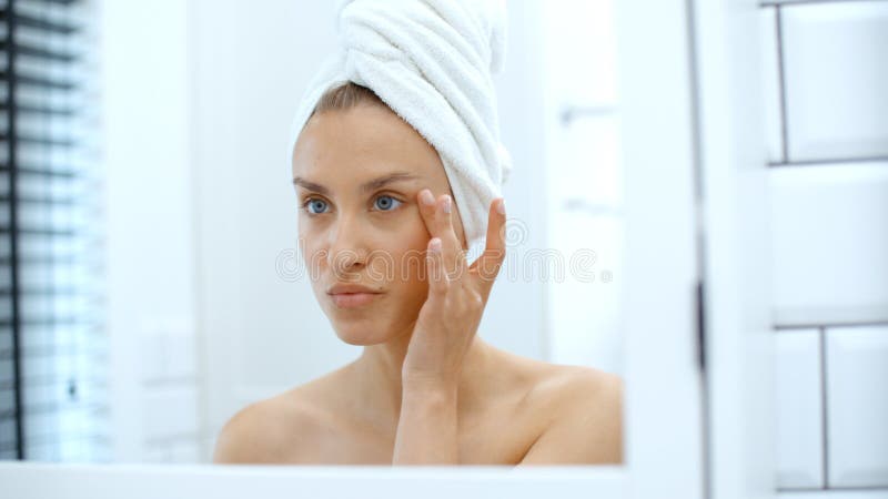 Young Woman Examining Herself in Front of Mirror Stock Image - Image of ...
