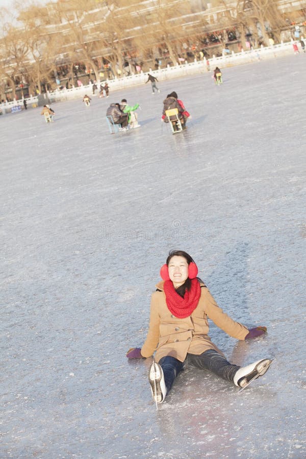 Young Woman Falling while Ice Skating Stock Image - Image of black ...