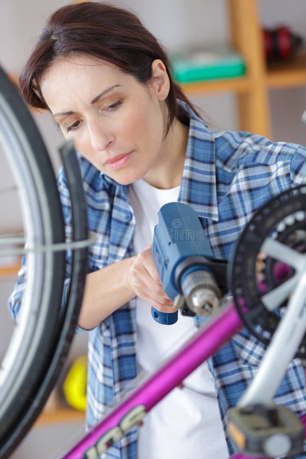 Young woman fixing bike stock image. Image of fixing - 86206535