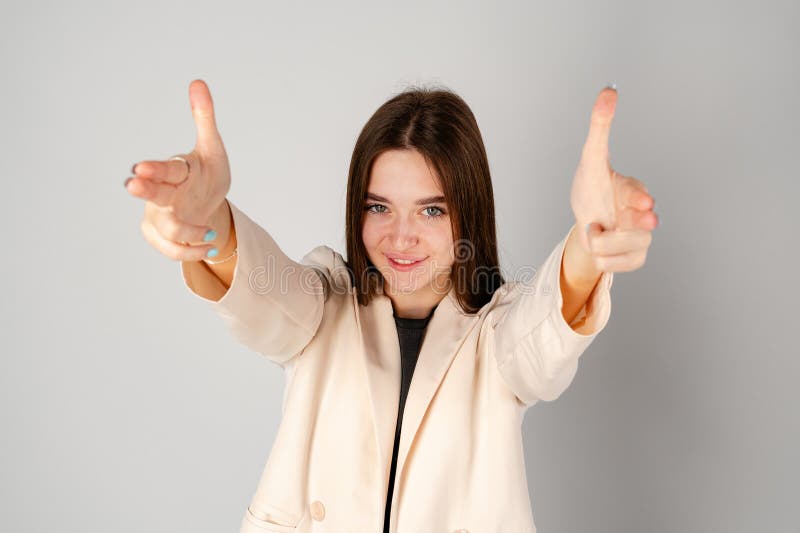 Young Woman Gesturing with Hands in Frame Against Plain Background ...