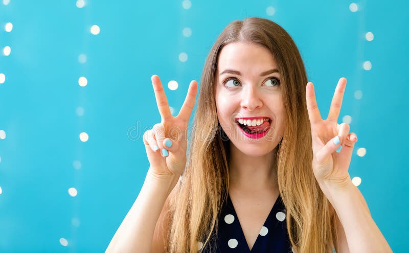 Young Woman Giving the Peace Sign Stock Photo - Image of bokeh, fingers ... Young Woman Giving the Peace Sign Stock Photo - Image of bokeh, fingers ...