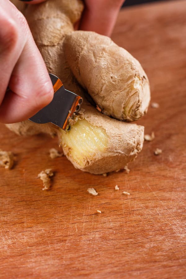 Young Woman in a Gray Apron Peeling a Ginger Root Stock Image - Image ...
