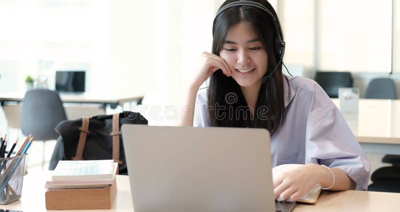 Young Woman Having Online Training, Using Laptop and Wireless Headset ...