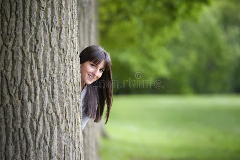 Young Woman Hiding Behind a Tree Stock Photo - Image of lifestyle, beauty: 31555846