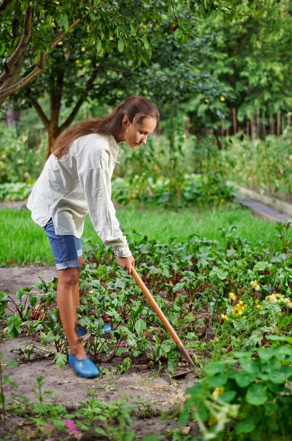 Young Woman with Hoe Working in the Garden Bed Stock Image - Image of ...