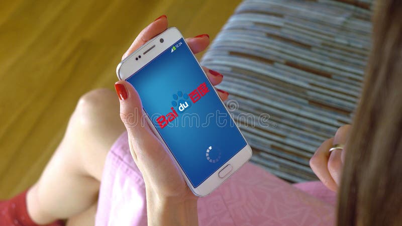 Young Woman Holding a Cell Phone with Loading Baidu Mobile App ...