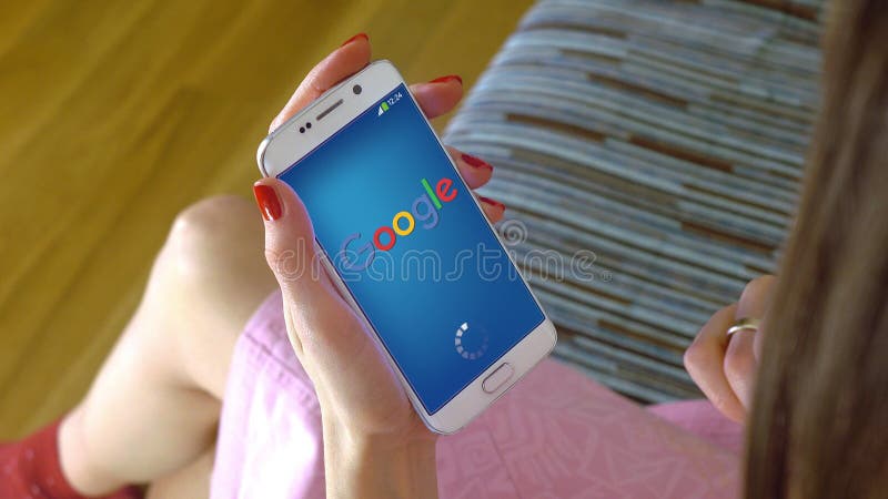 Young Woman Holding a Cell Phone with Loading Google Mobile App ...