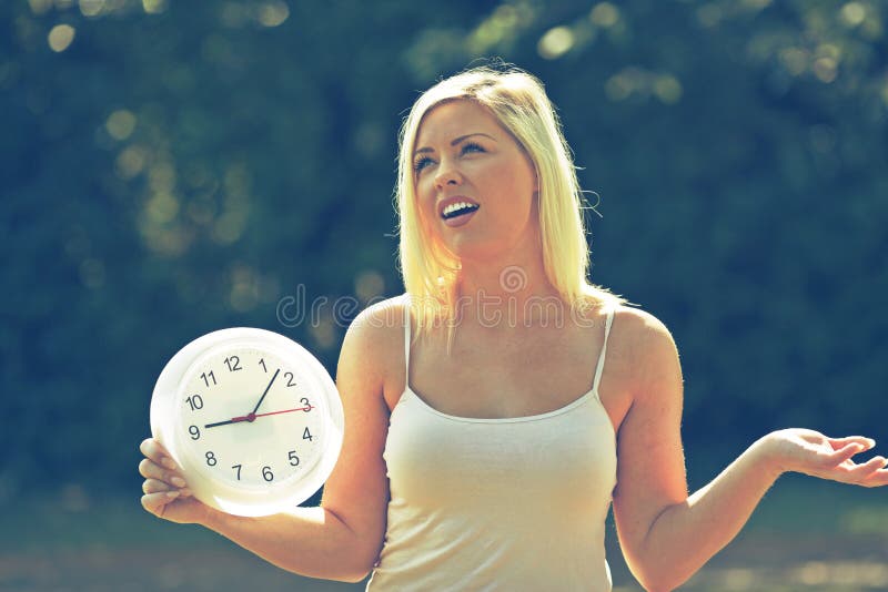 Young Woman Holding Clock and Pointing it by Finger Stock Photo - Image ...