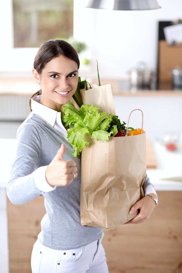 Young Woman Holding Grocery Shopping Bag with Vegetables . Standing in ... Young Woman Holding Grocery Shopping Bag with Vegetables . Standing in ...