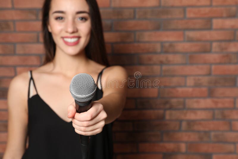 Young Woman Holding Microphone Near Brick Wall Stock Image - Image of ...