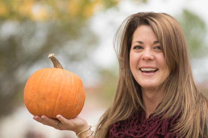 Young Woman Holding a Pumpkin in a Fall Setting. Stock Photo - Image of ... Young Woman Holding a Pumpkin in a Fall Setting. Stock Photo - Image of ...